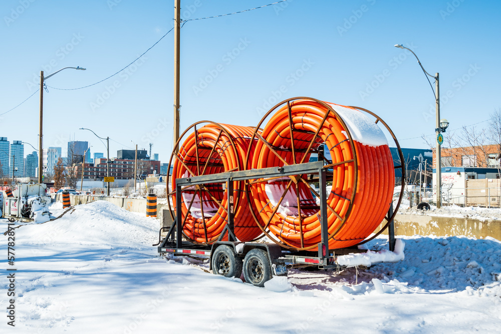 Large spools of smooth walled HDPE plastic cable (orange) conduit on ...