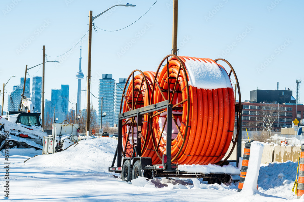 Large spools of smooth walled HDPE plastic cable (orange) conduit on ...