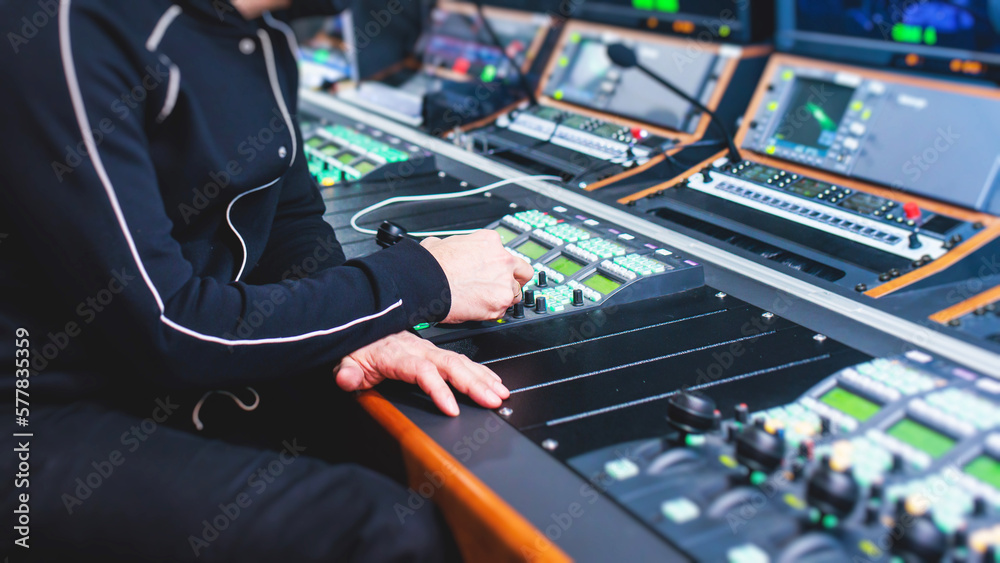 View of lighting technician operator working on mixing console ...