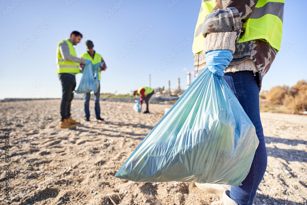 Group portrait of activists holding plastic waste. Teamwork standing up ...