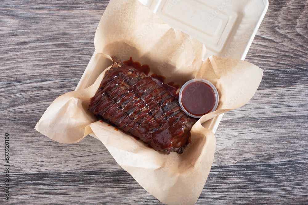 A top down view of a container holding an order of half rack baby back ...