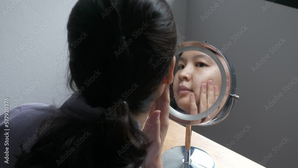 Rear view, over shoulder, reflection of young Asian woman in bathrobe ...