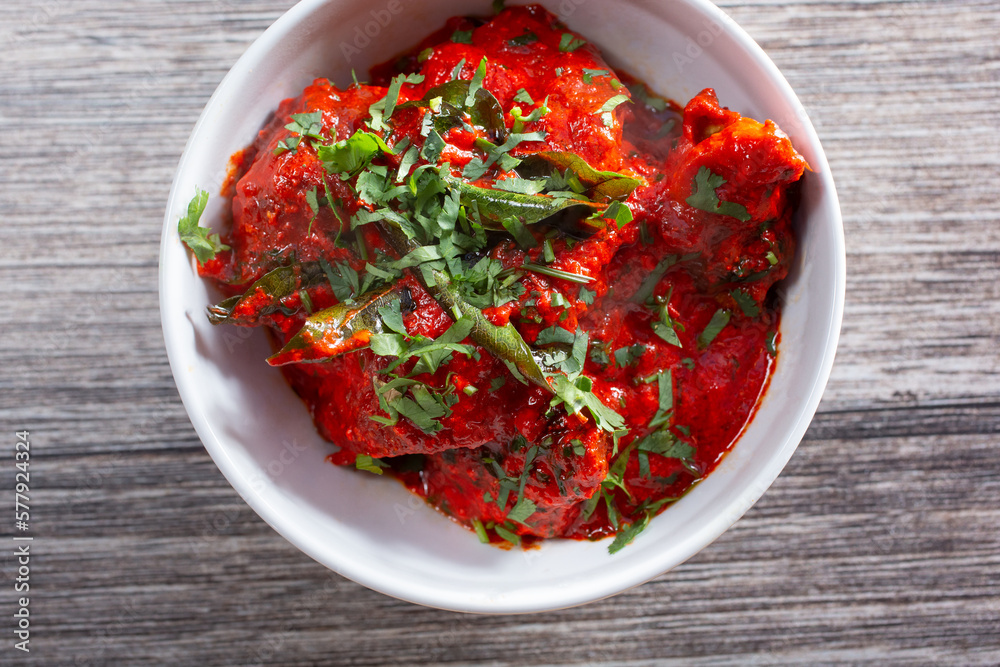 A top down view of a bowl of deep fried chicken entree, with a spicy ...