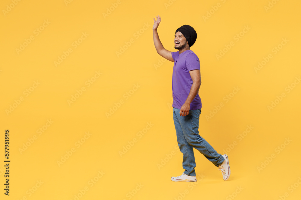 Full body fun side view smiling cheerful devotee Sikh Indian man ties ...