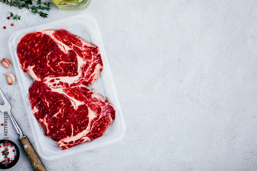 Ground Beef steak in vacuum packaging with seasonings on gray stone ...