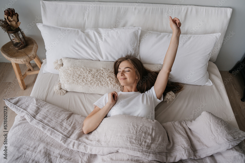 Young long haired Italian girl laying on bed eyes closed awakening at ...