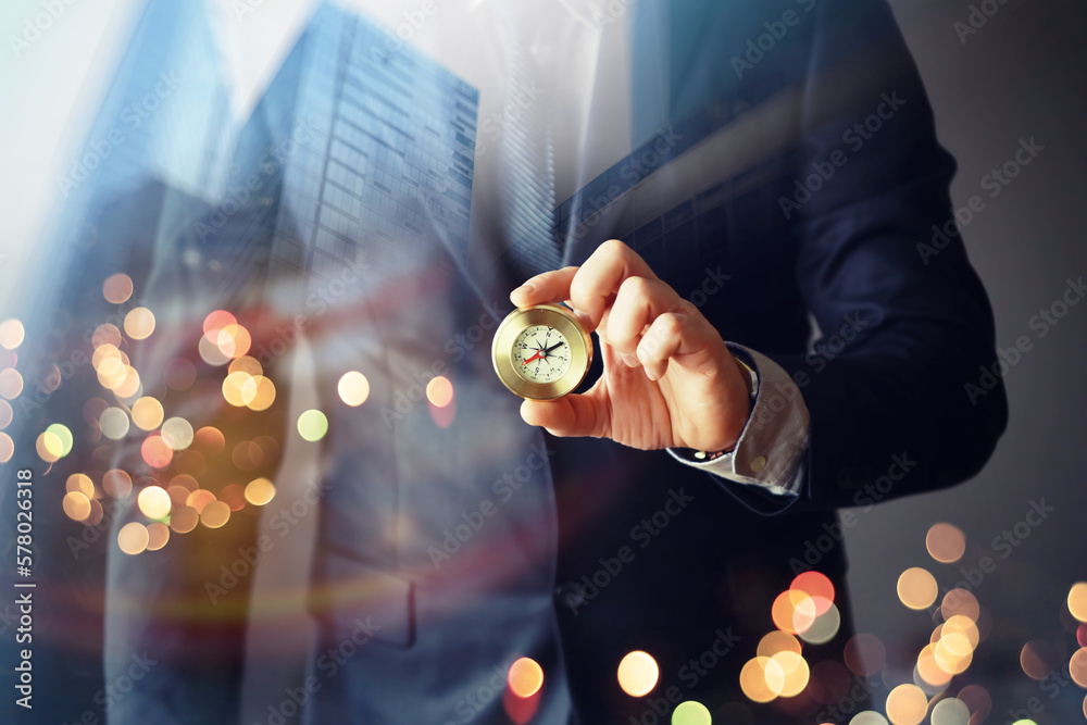 Man with black suit showing compass, double exposure, skyscraper ...