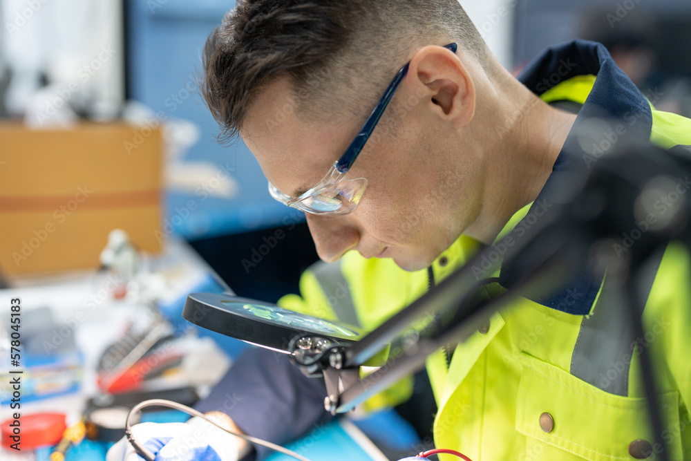Male electrical engineer using digital multimeter checking voltage on ...