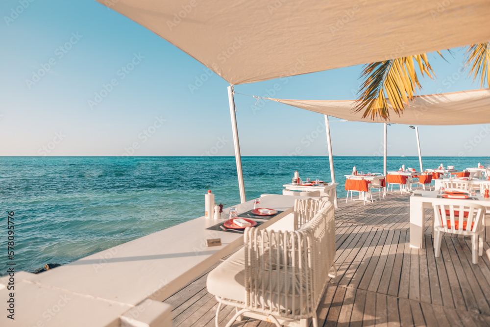 Relaxing outdoor restaurant at the beach. Table setting at tropical ...