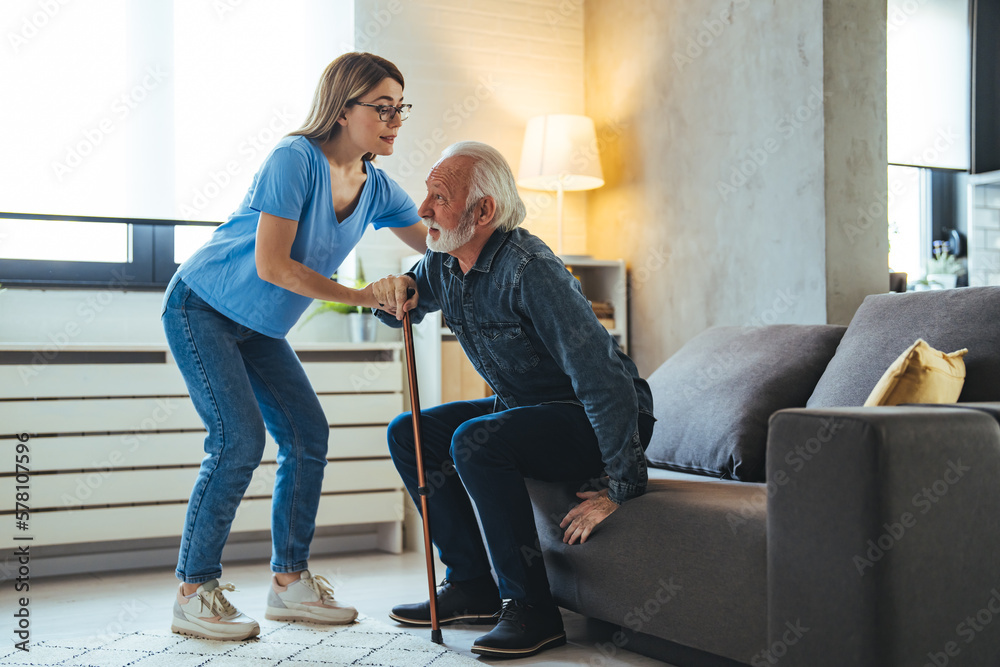 Doctor or nurse caregiver helping senior man with a walking cane stick ...