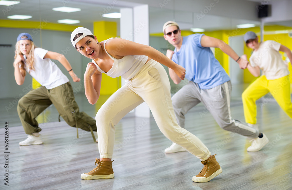 Group of cool, active teenage dancers having fun and learning new dance ...