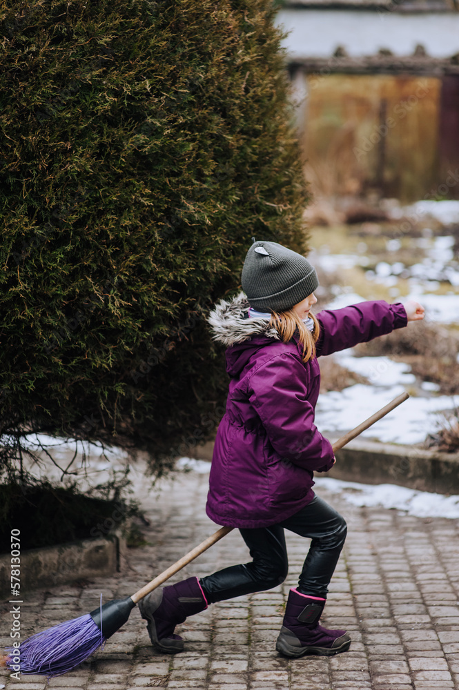 A little girl, a child sits on a broom, depicting the flight of a ...