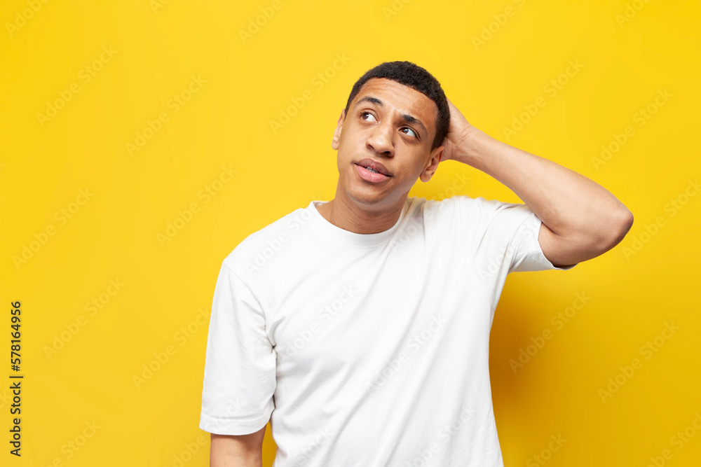 young pensive guy afro american confused scratches his head and ...