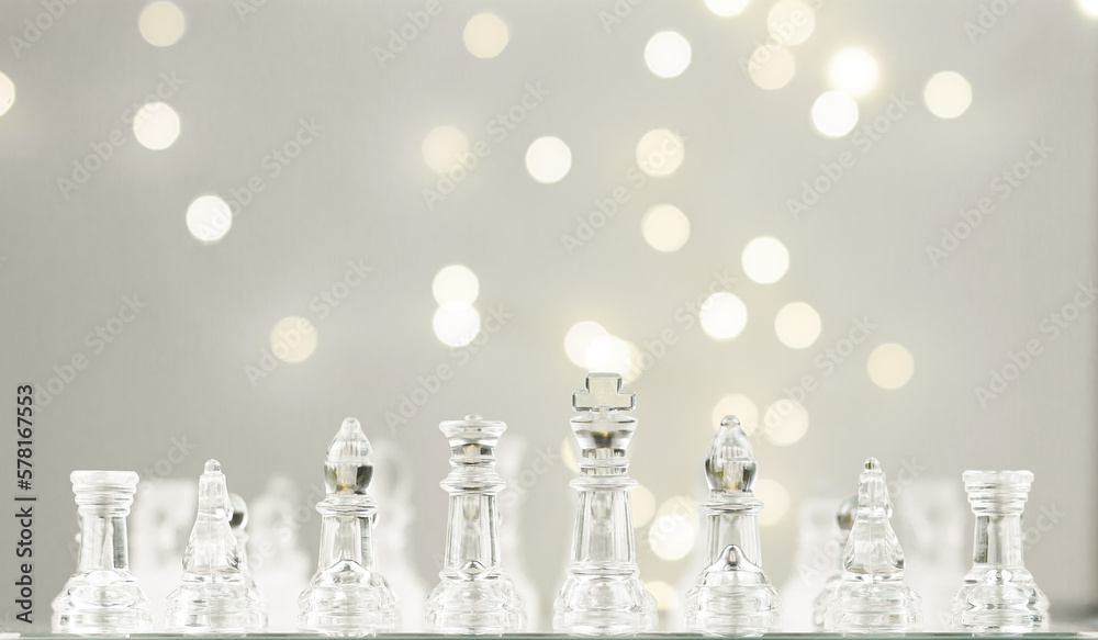 Glass chess on a light background with blurred lights and highlights ...