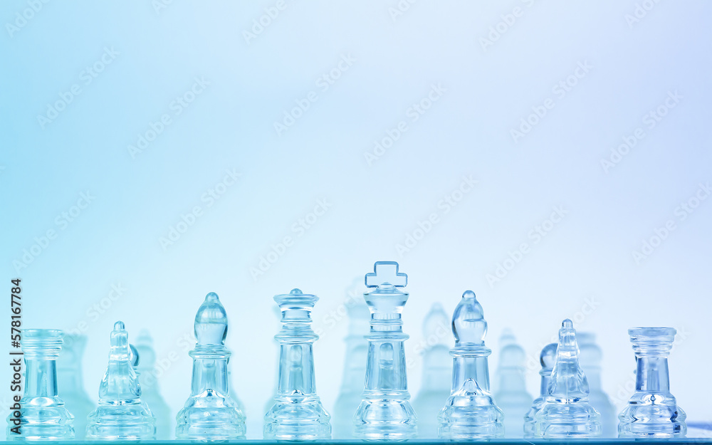 Glass chess in a row on a blue background with space for a copy. Glass ...