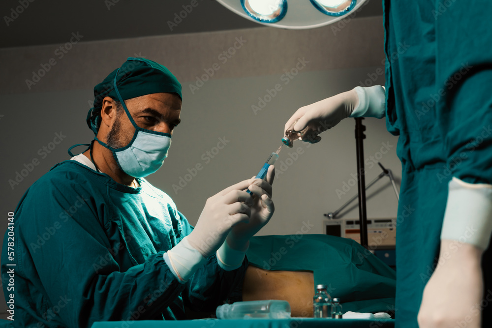 Surgeon fill syringe from medical vial for surgical procedure at ...