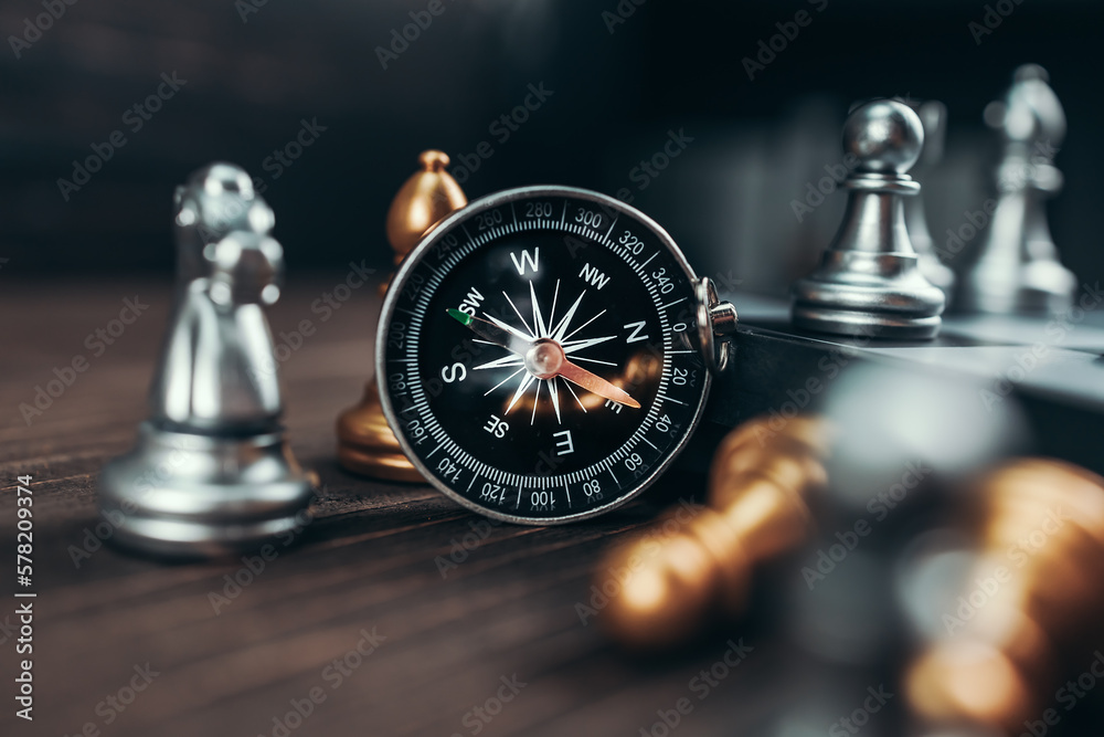 compass and chess piece on chess board game for ideas, challenge ...
