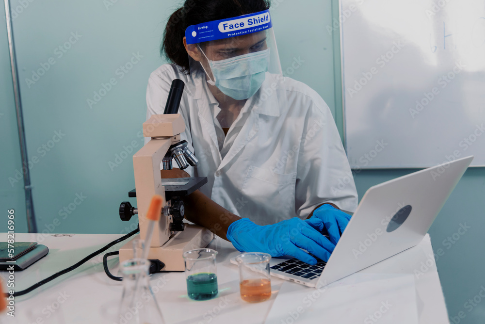 Indian Scientist man looking Microscope using laptop analyze research ...