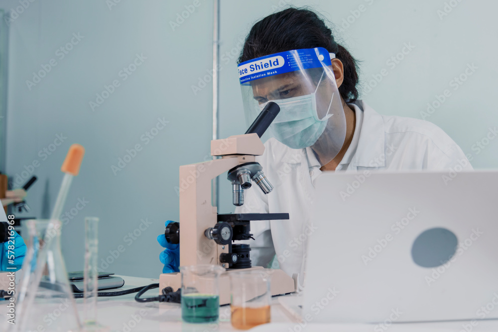 Indian Scientist man looking Microscope using laptop analyze research ...