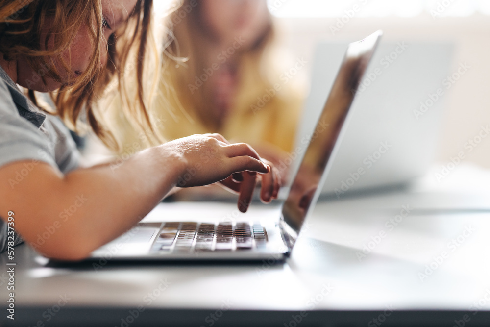 Young boy hitting the keyboard in a classroom, completing a digital ...