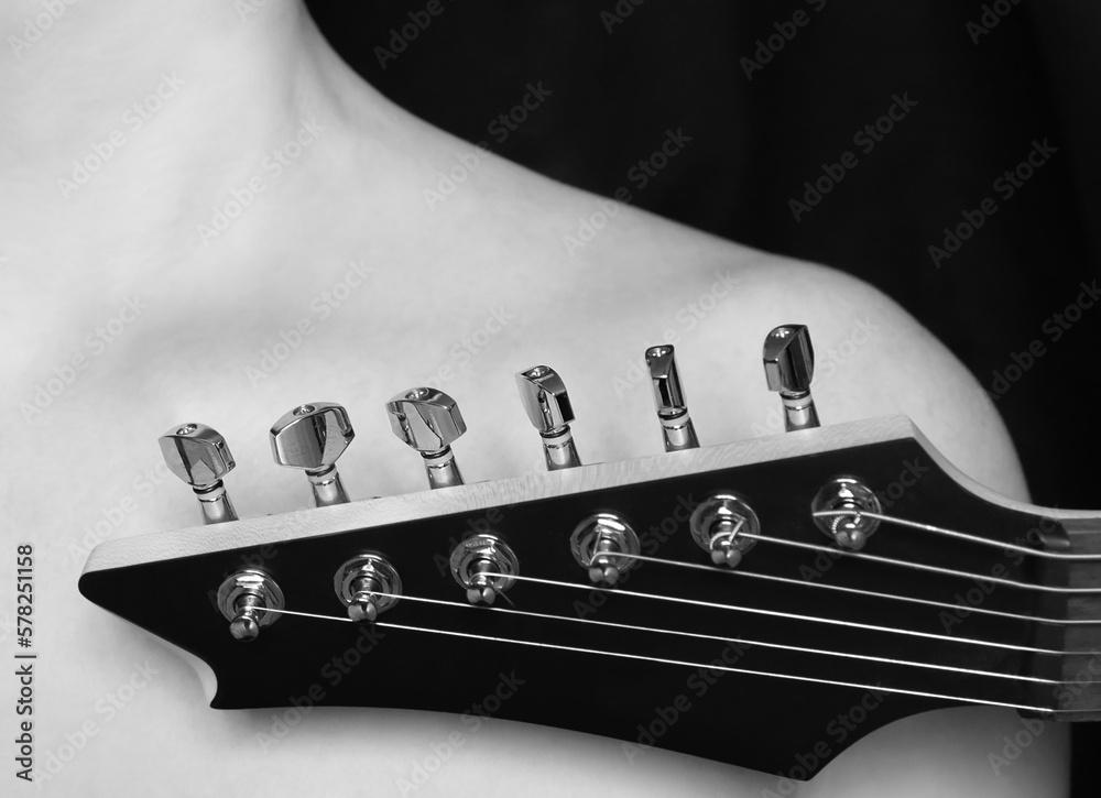 fragment of an electric guitar in front of female body. Aesthetics of ...