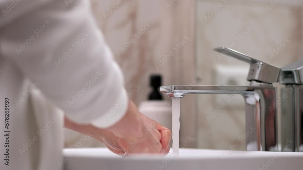 The man turns on the water, lathers his hands and washes his hands ...