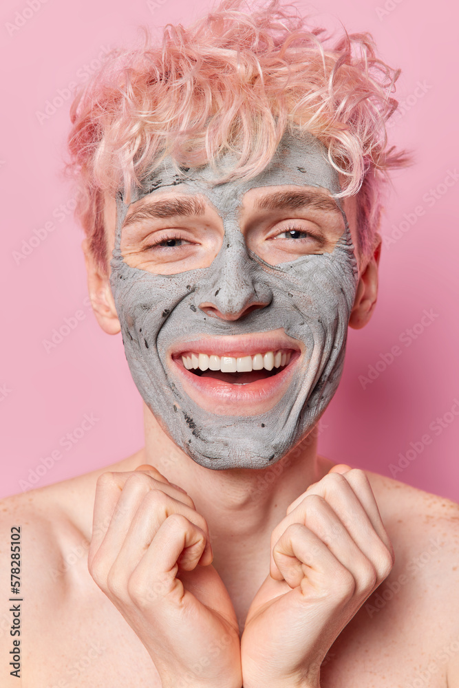 Vertical shot of cheerful guy smiles broadly shows white teeth keeps ...