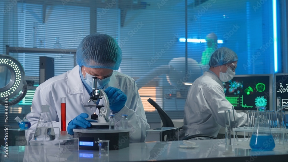 Modern medical research laboratory. The researcher examines the sample ...