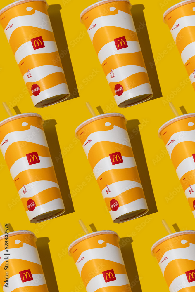 Yellow glass of McDonald's pattern. Paper cup with lid. Takeaway drink ...