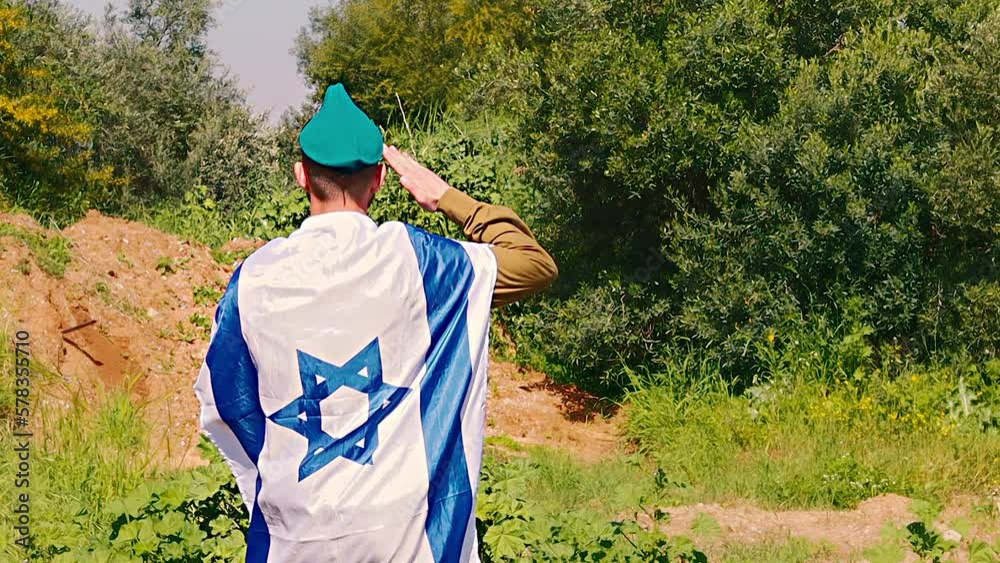 Israeli Army Soldier salutes with a large Flag of Israel on his back ...