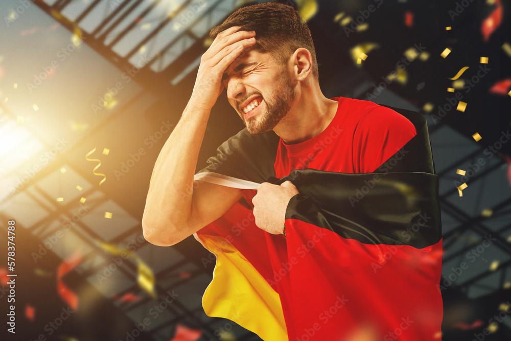 Losing game. Young man, football fan with german flag cheering up ...