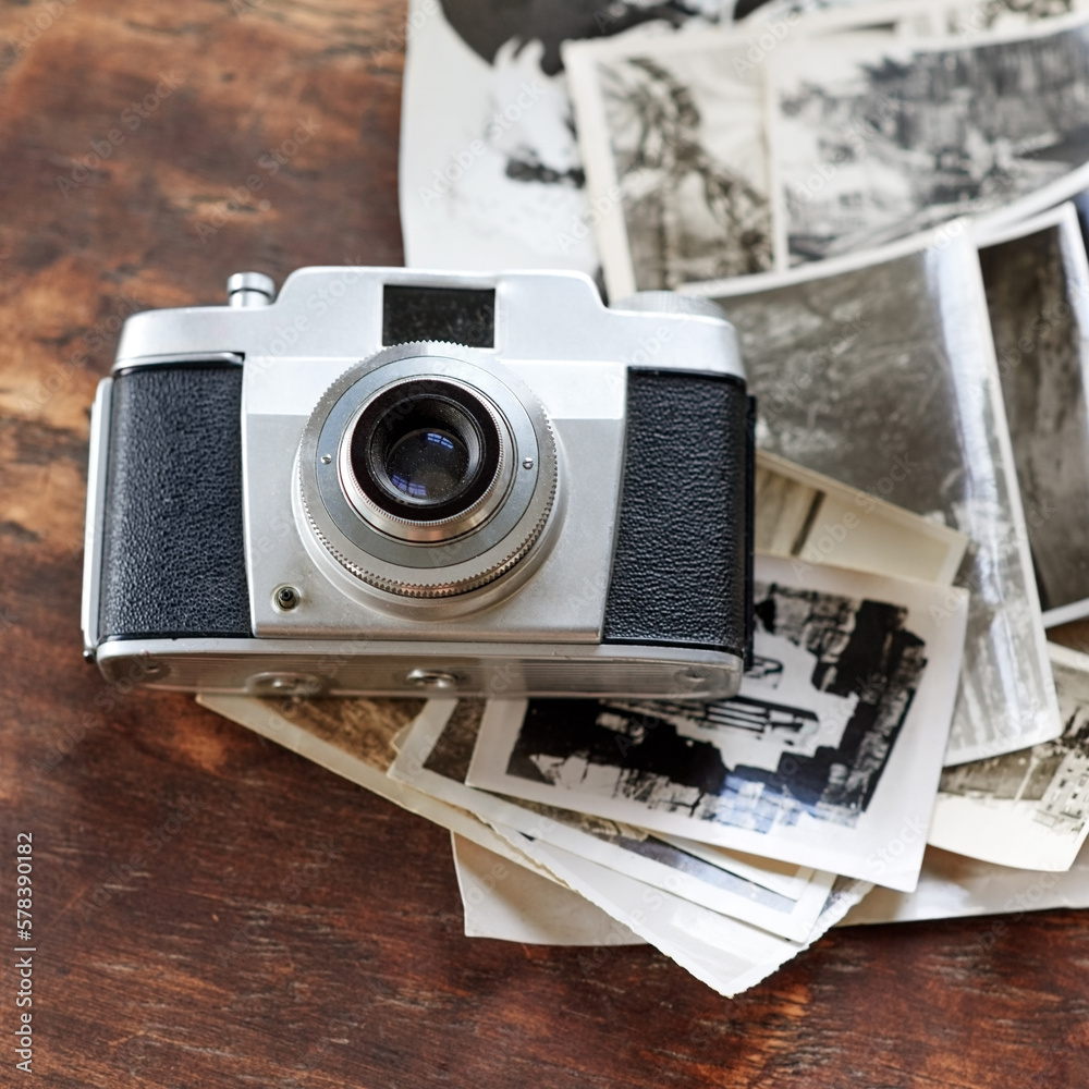 Treasure your memories. An old-fashioned camera lying on top of a pile ...
