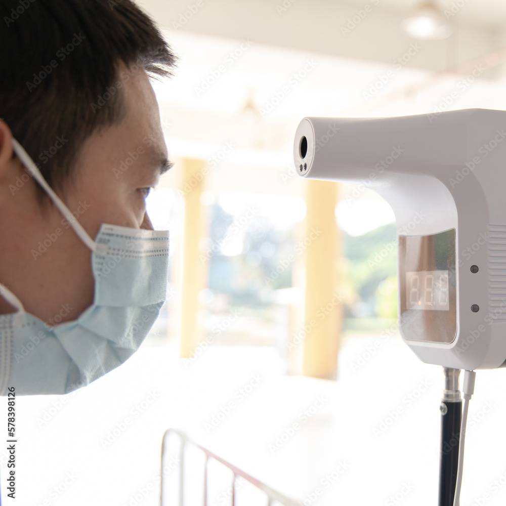 Man approached the forehead thermometer sensor to detect body heat ...