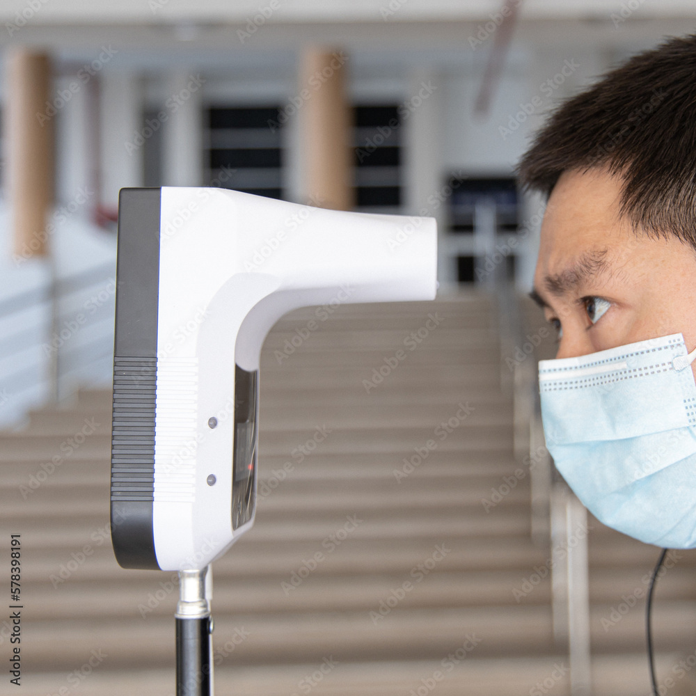 Man approached the forehead thermometer sensor to detect body heat ...