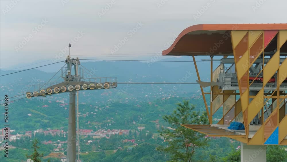Ropeway, cable car cabins are moving against gray sky and mountains in ...