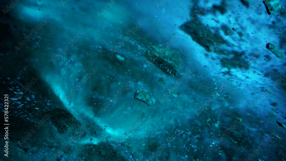 Turquoise pure color of ice inside the ice cave. Stones and icicles are ...