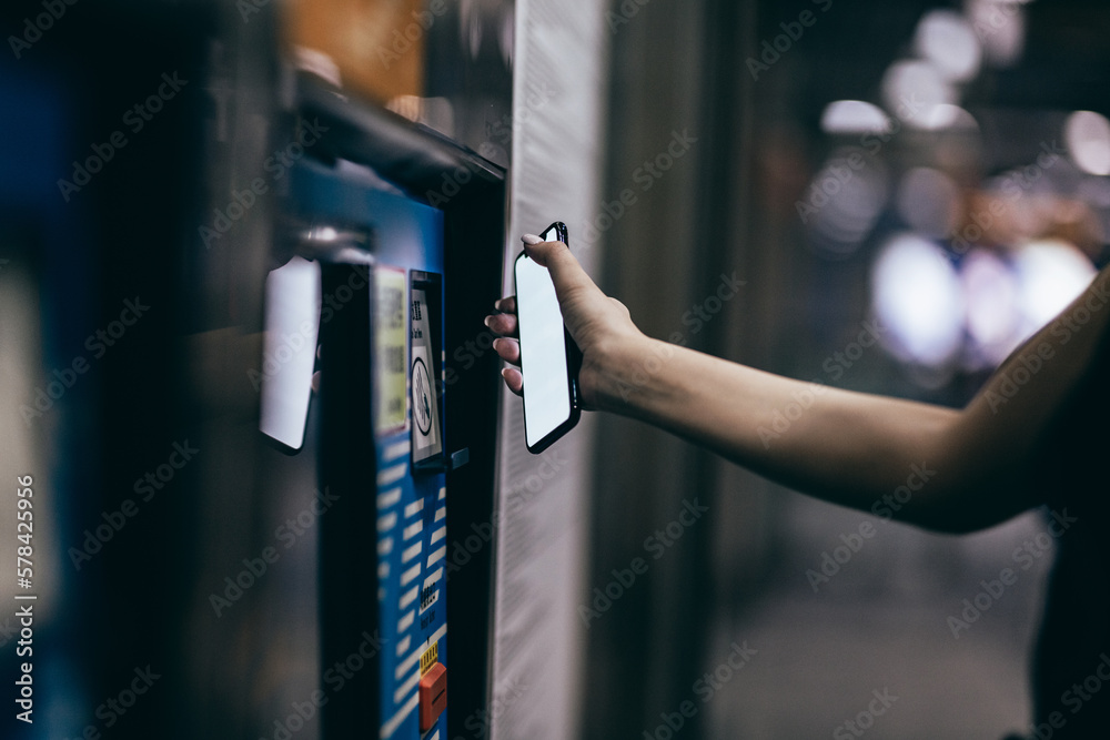 Foto de Cropped shot of young Asian woman scanning QR code, checking in ...