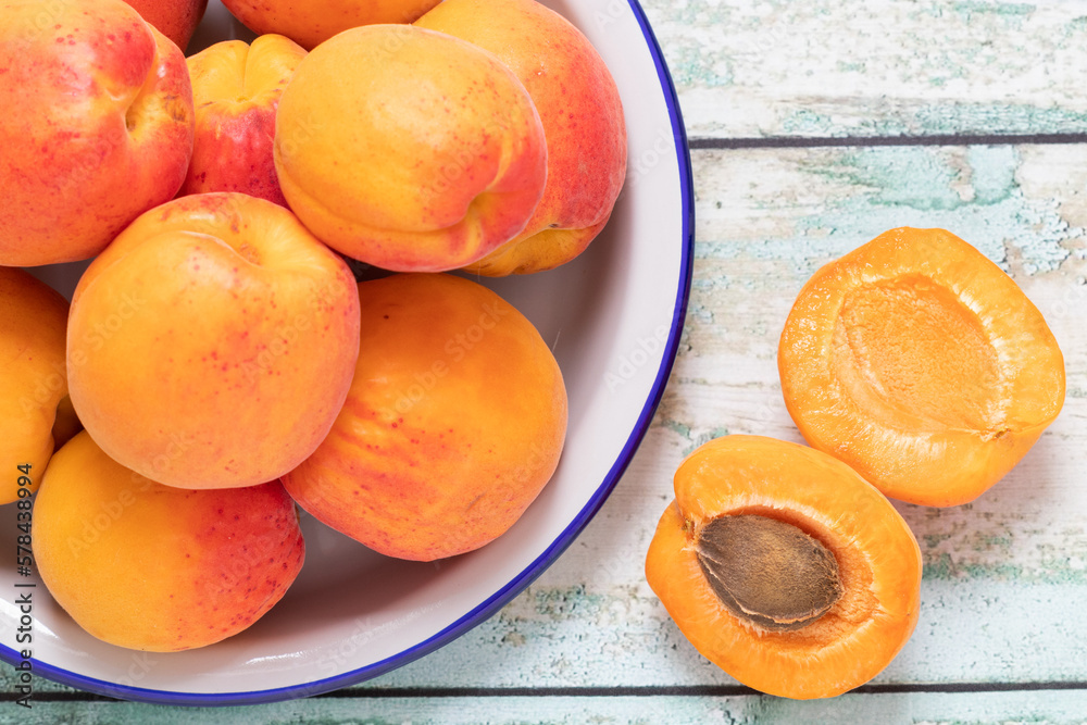 Top view photo of bio apricots on a plate with a rustic wood texture ...