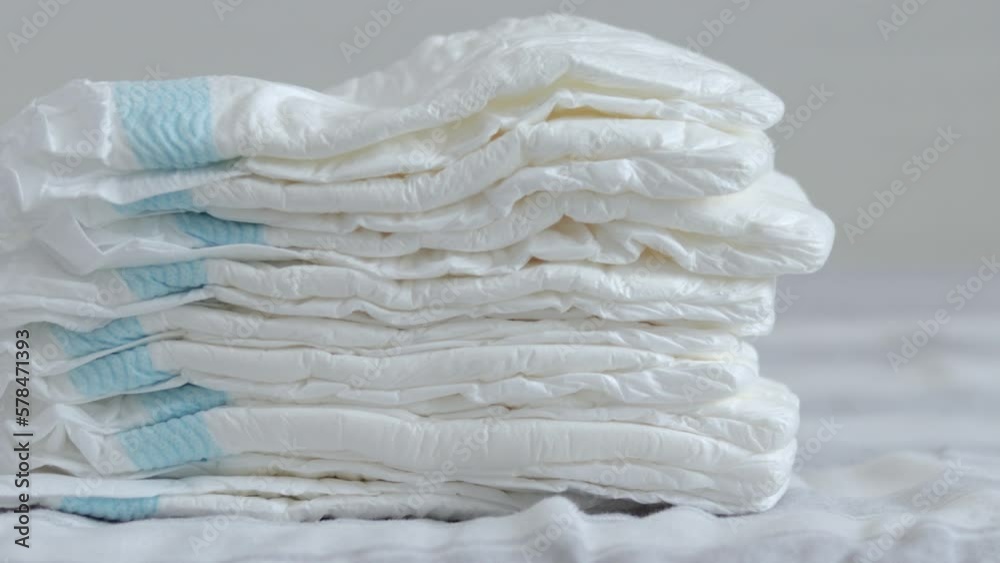baby stack many diapers on bed woman mother hand taking one or pressing ...