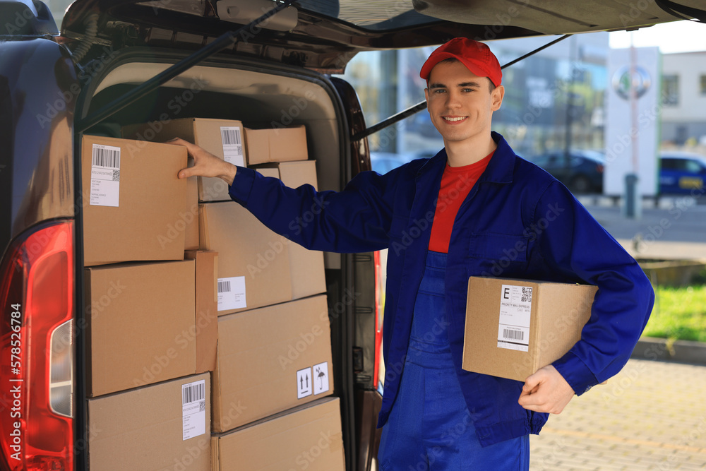 Courier with parcel near delivery van outdoors Stock Photo | Adobe Stock