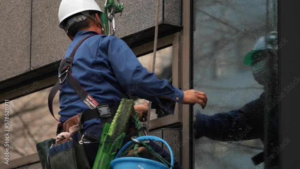 Workers cleaning the windows of an office building. 4K video with ...