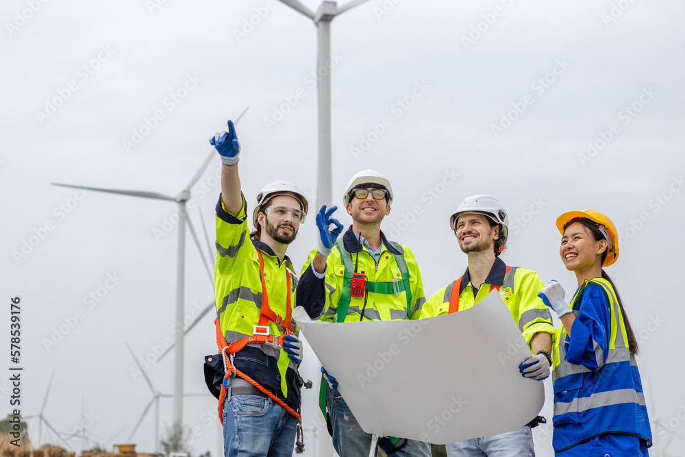 Foto de Teamwork engineer worker wearing safety uniform holding and reading blueprint at wind ...