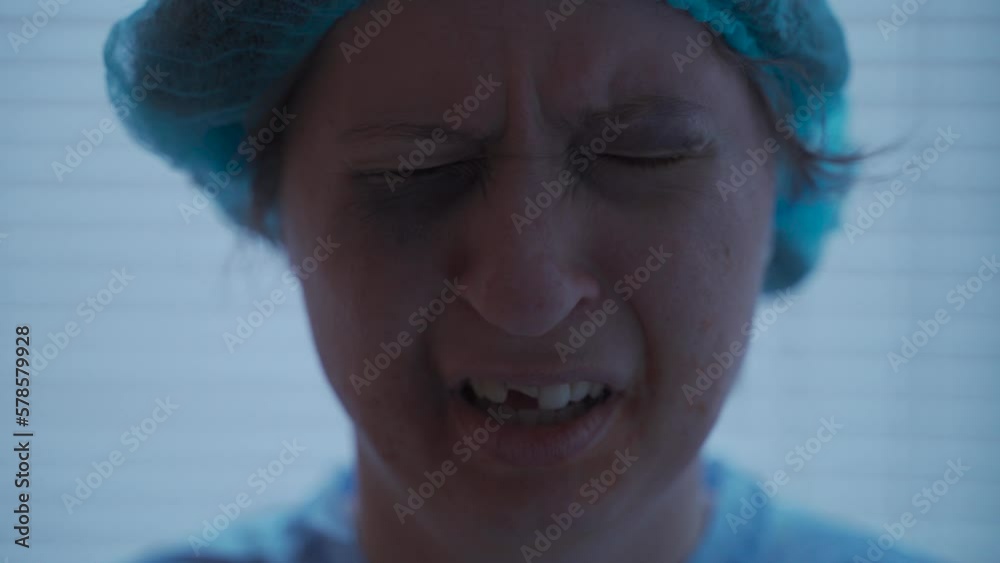A scared, traumatized woman with injuries to her teeth and face looks ...
