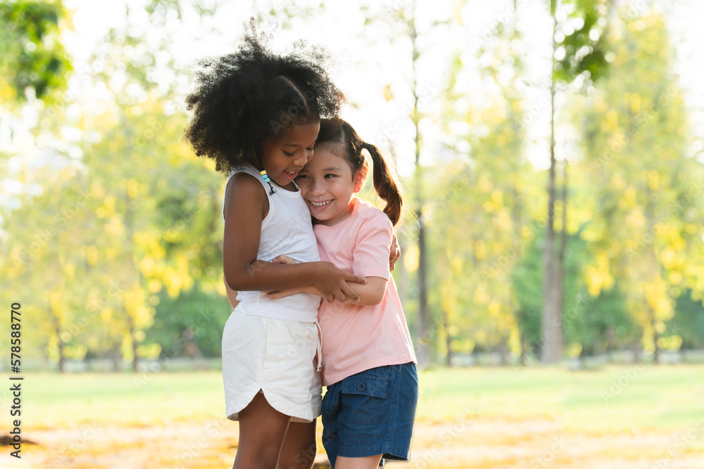 Happy little Caucasian and African children playing together at park ...