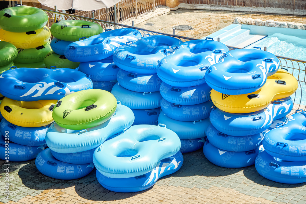 Multi-colored rubber rings for swimming pool put in rows at bright ...