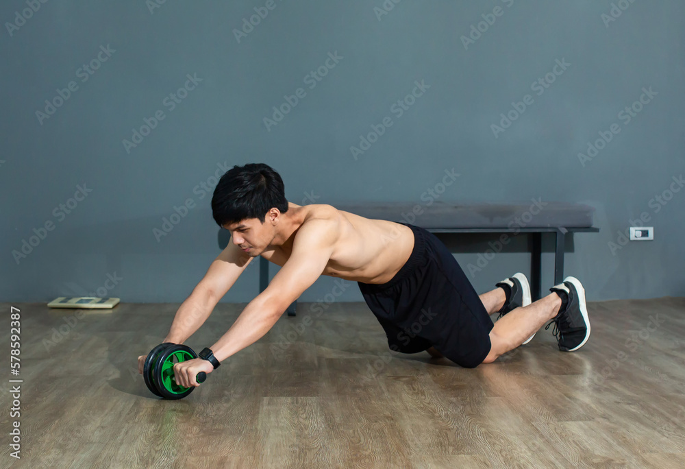 Asian handsome man black hair doing exercise with pushup wheel forward ...