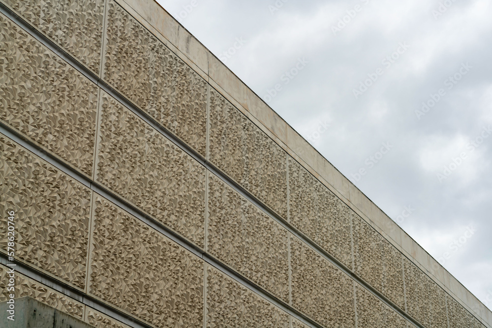 Ridged and textured building wall facade with geometric block and ...