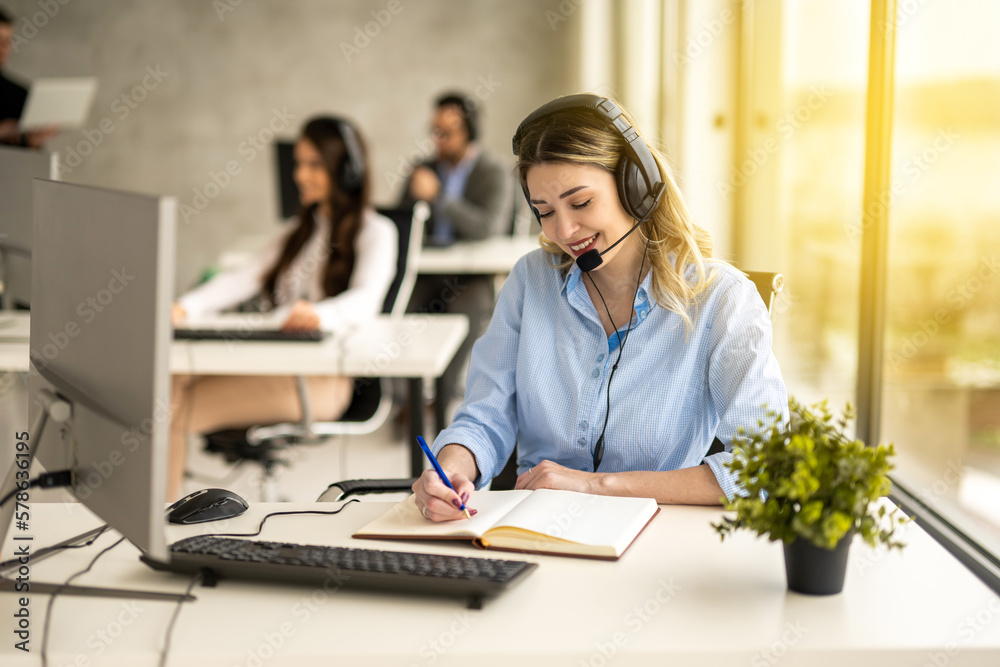 IT service support agent taking notes while talking with custumer ...