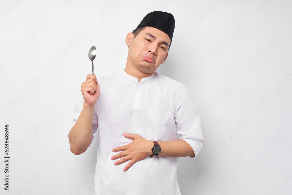 Feeling hungry young Asian Muslim man touching hand on the stomach ...