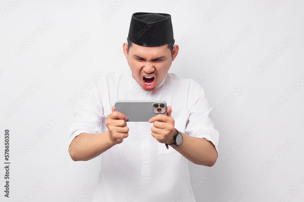 Angry handsome young Asian Muslim man wearing Arabic clothes playing ...
